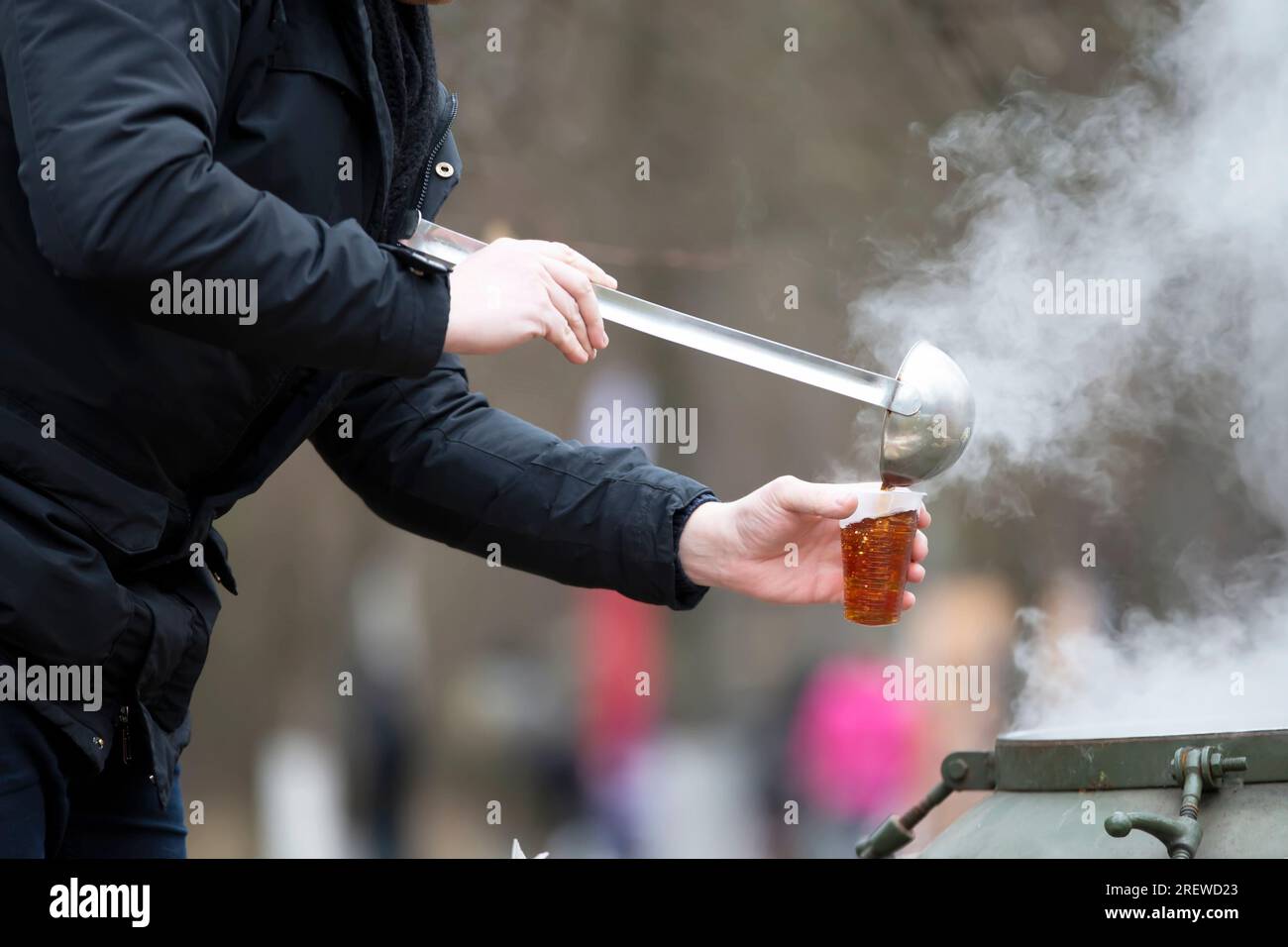 Tea master pours tea in a plastic glass outdoors Stock Photo - Alamy