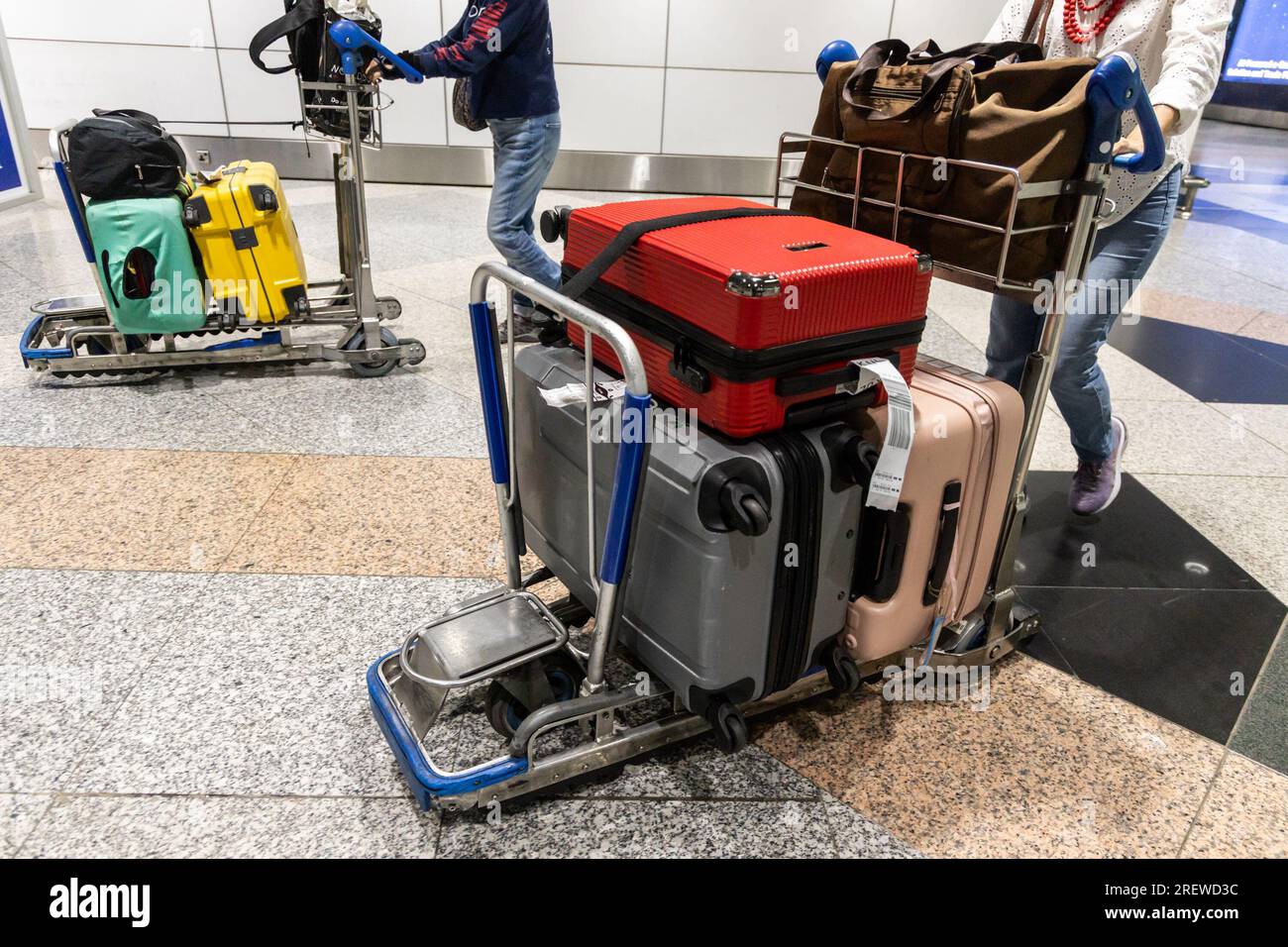 Traveller pushing trolley with luggages and bags in airport terminal ...
