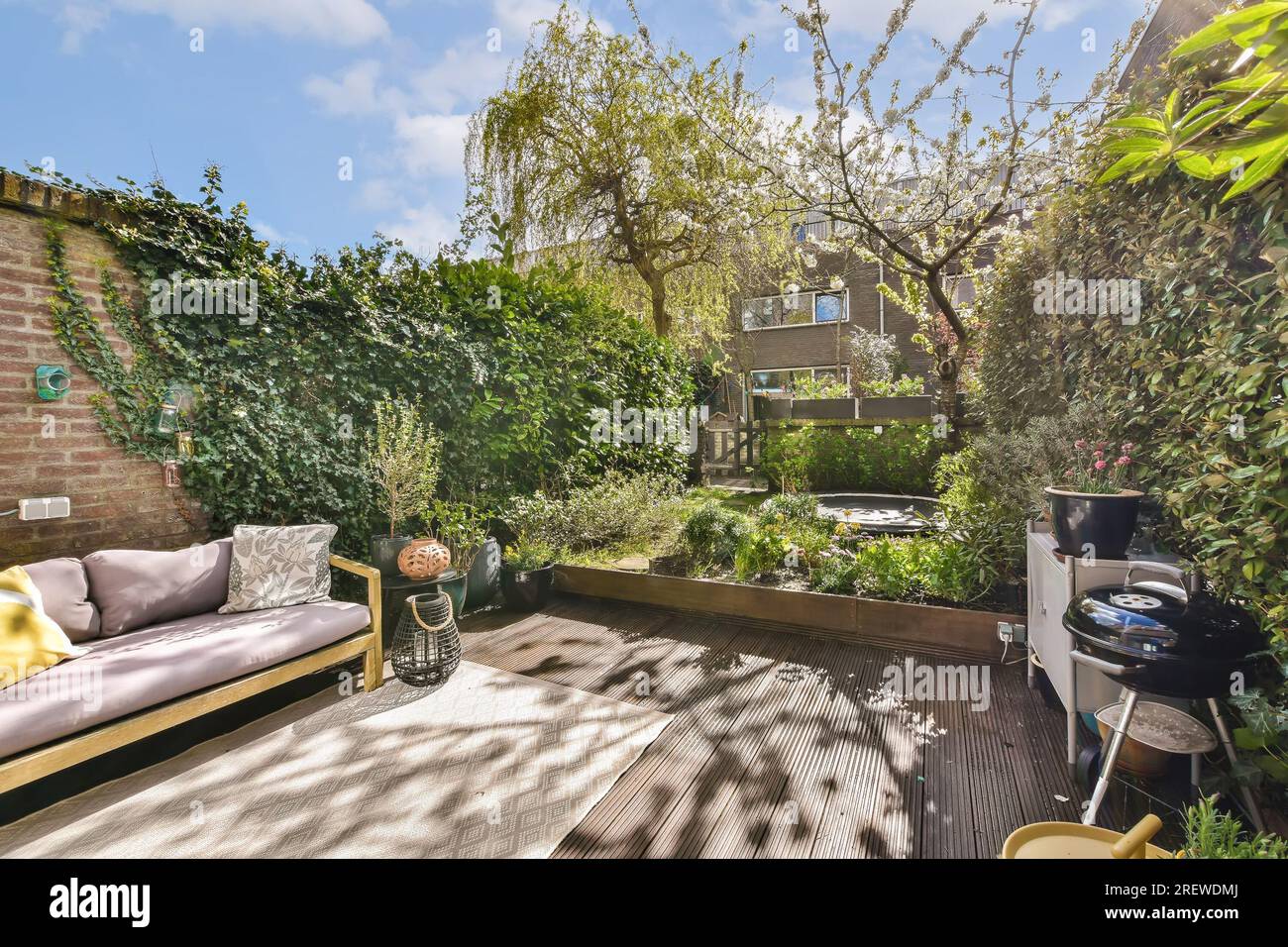 an outdoor living area with wooden decking and plants in the fore ...