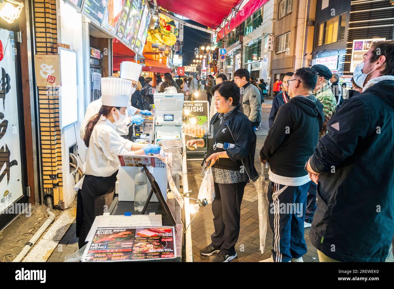 Night time view along the take away counter with two chefs serving ...