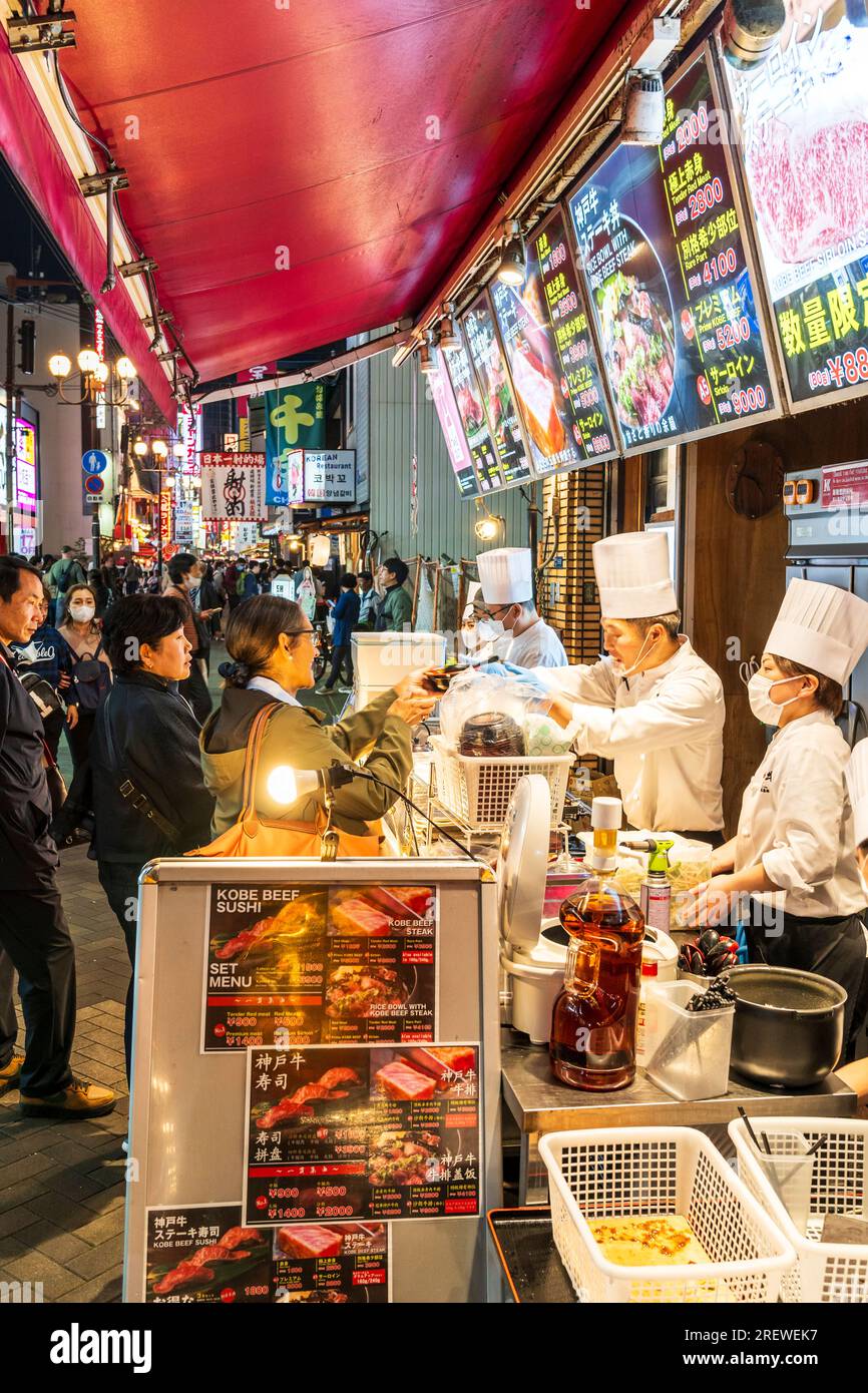 Night time view along the take away counter with several chefs serving ...