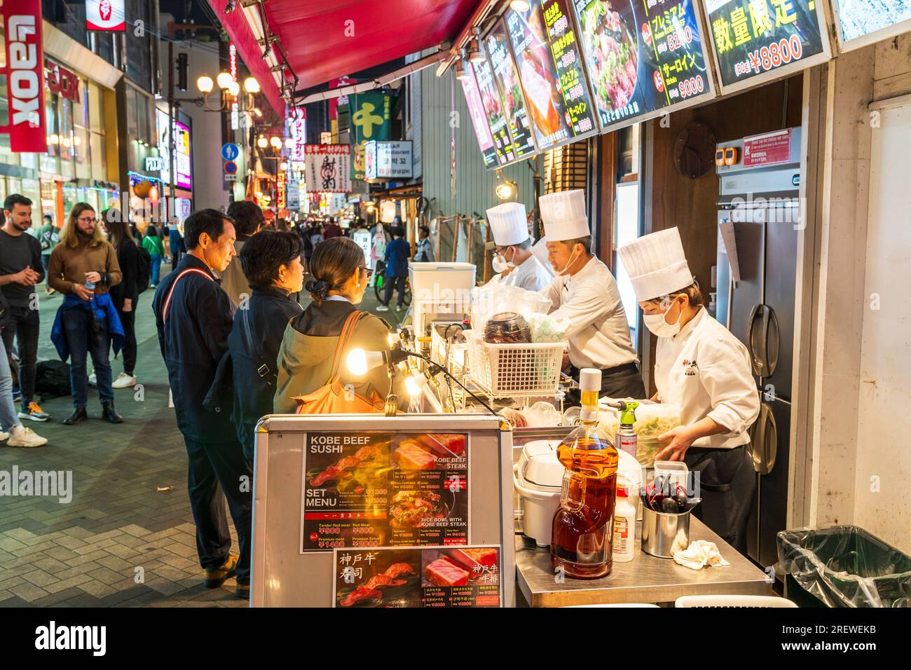Night time view along the take away counter with several chefs serving ...