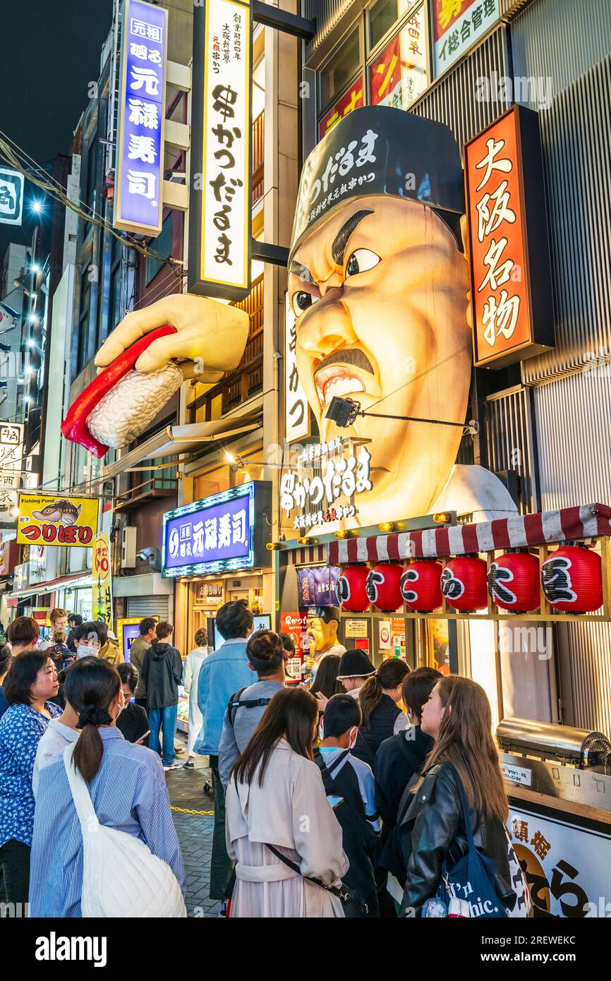 People queuing at night outside the entrance of the popular Kushikatsu ...