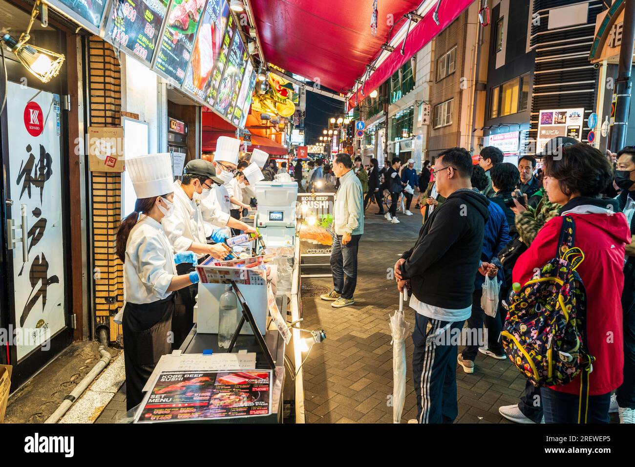 Night time view along the take away counter with several chefs serving ...