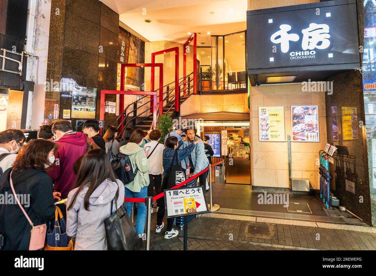 Queue of people outside the entrance to the Chibo Okonomiyaki ...