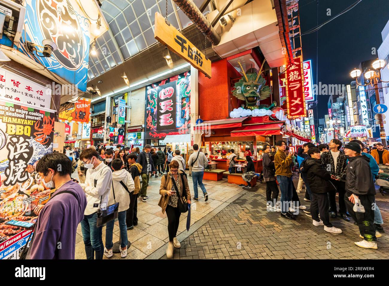 Busy nighttime scene at the entrance to Sennichimae Street with the famous Kinryu Ramen ...