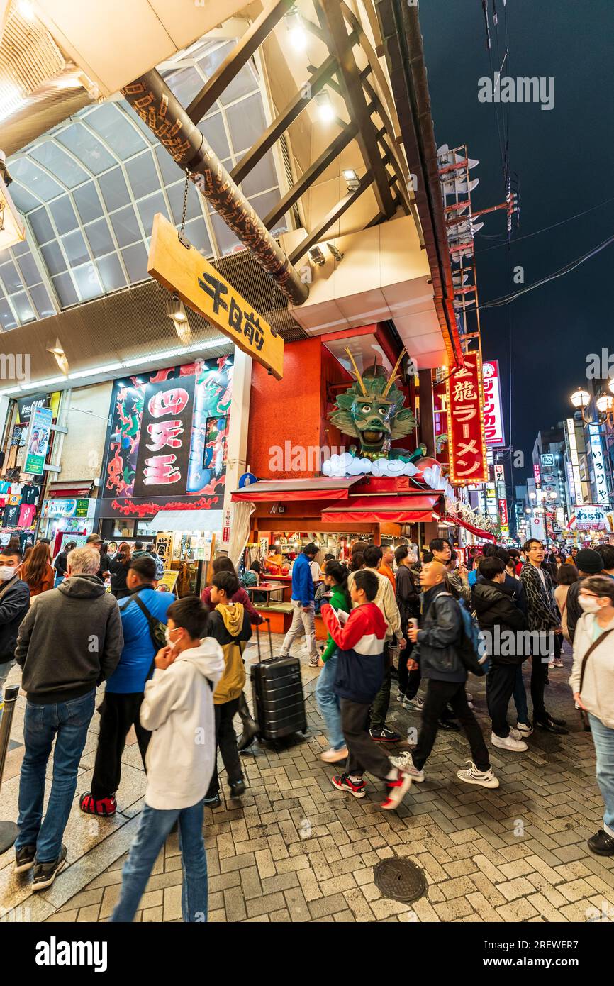 Busy nighttime scene at the entrance to Sennichimae Street with the ...