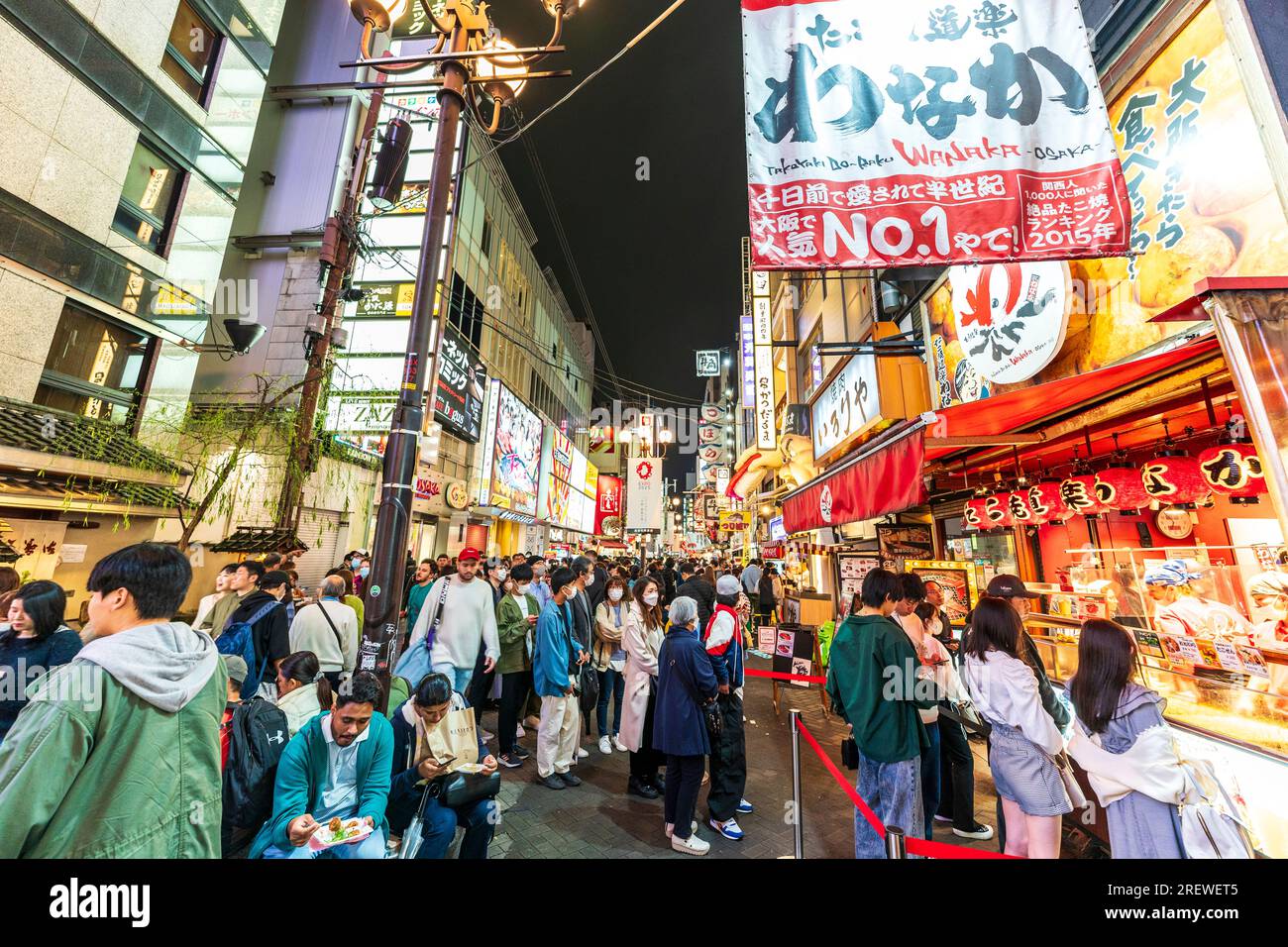 View along a busy and lively night time Dotonbori street, Osaka, with ...