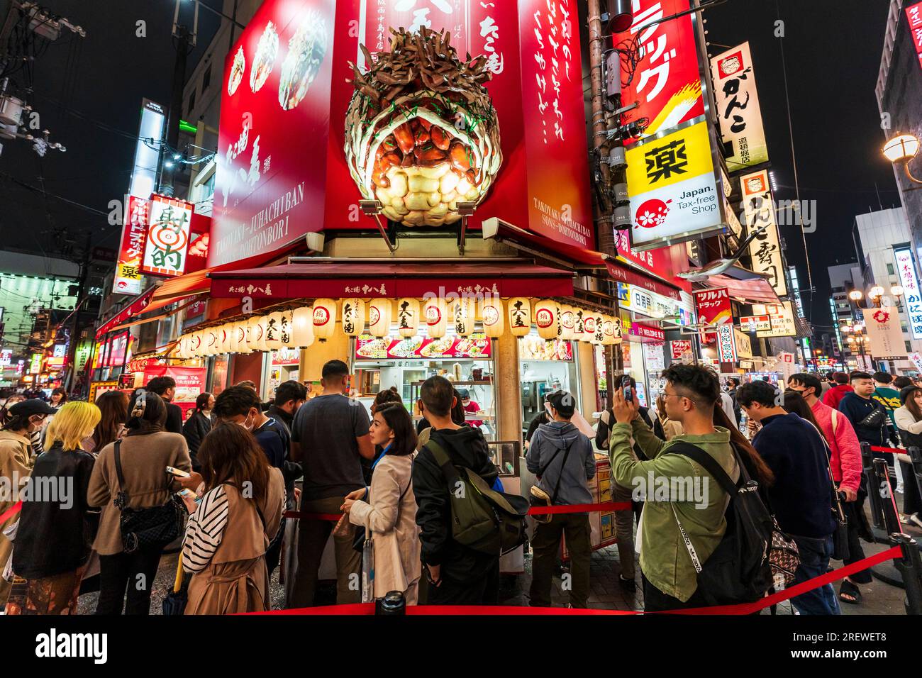 Busy scene with people both queuing and walking by the popular Takoyaji ...