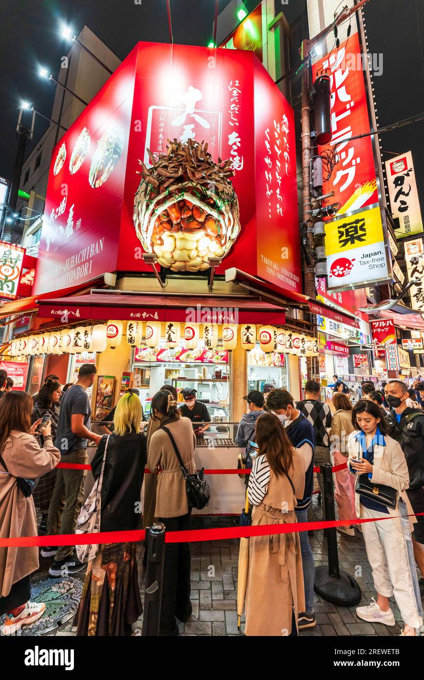 Busy scene with people both queuing and walking by the popular Takoyaji ...