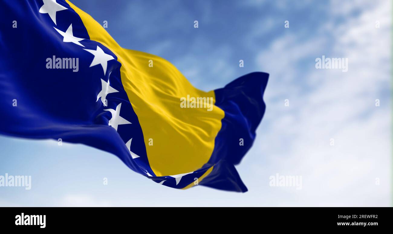 Flag of Bosnia and Herzegovina waving in the wind. Blue field with ...