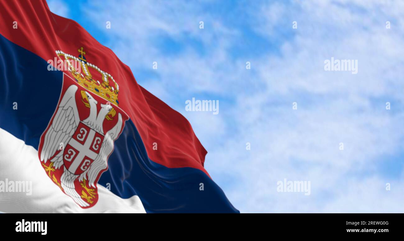 Nation flag of Serbia waving in the wind on a clear day. Red, blue and ...