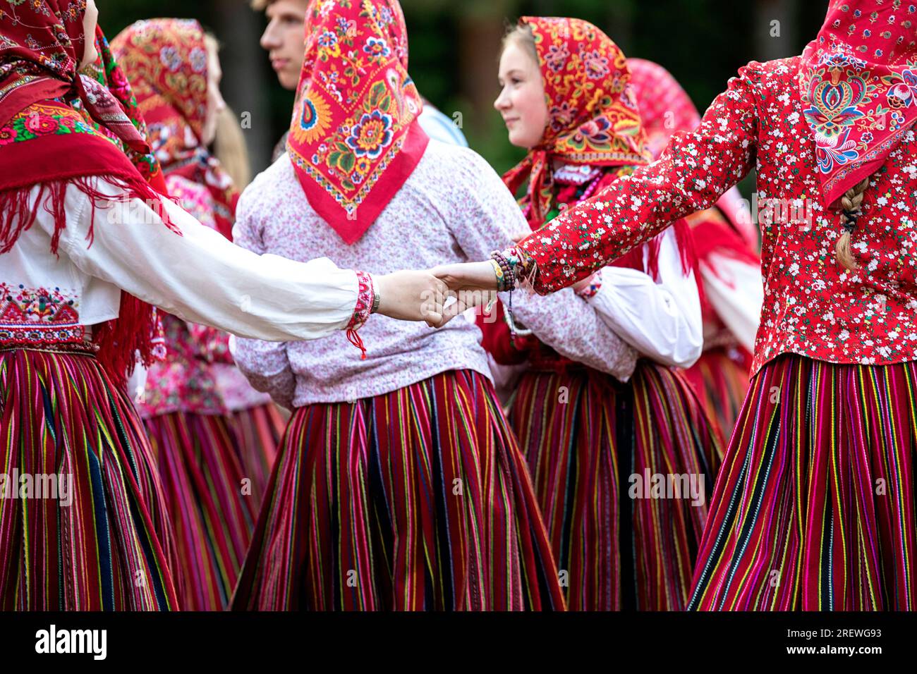 Girls in traditional estonian folk costumes holding hands, celebrating ...