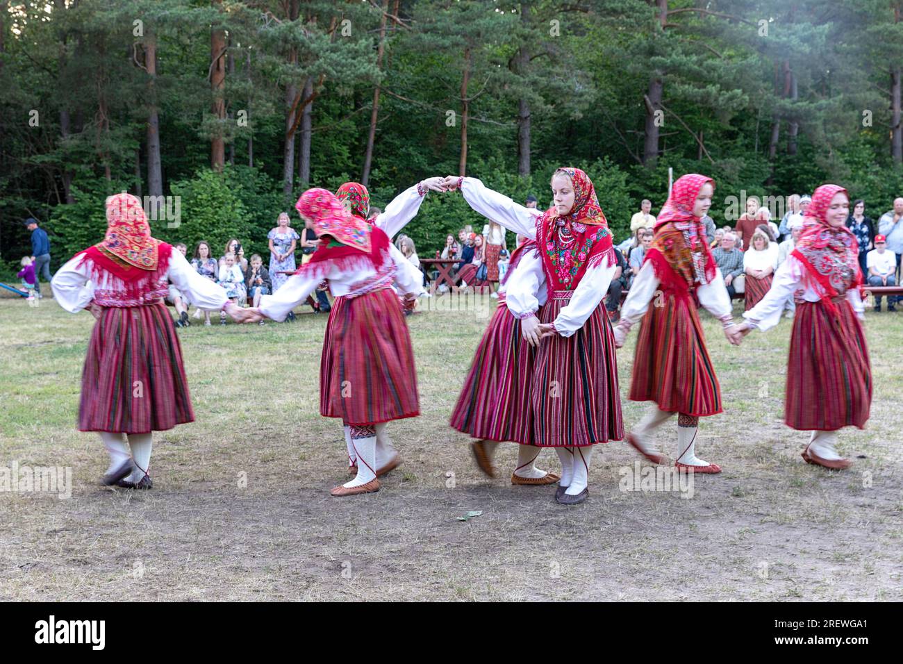 Girls in traditional estonian folk costumes dancing and celebrating estonian national holiday ...