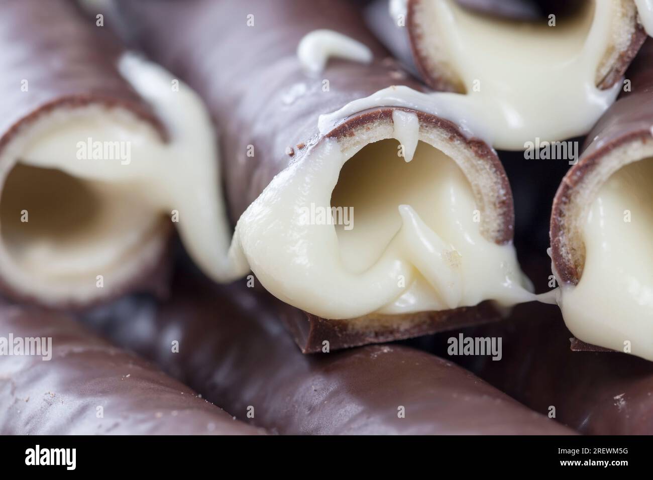 milk filling flows out of waffle tubes in chocolate, chocolate covered ...