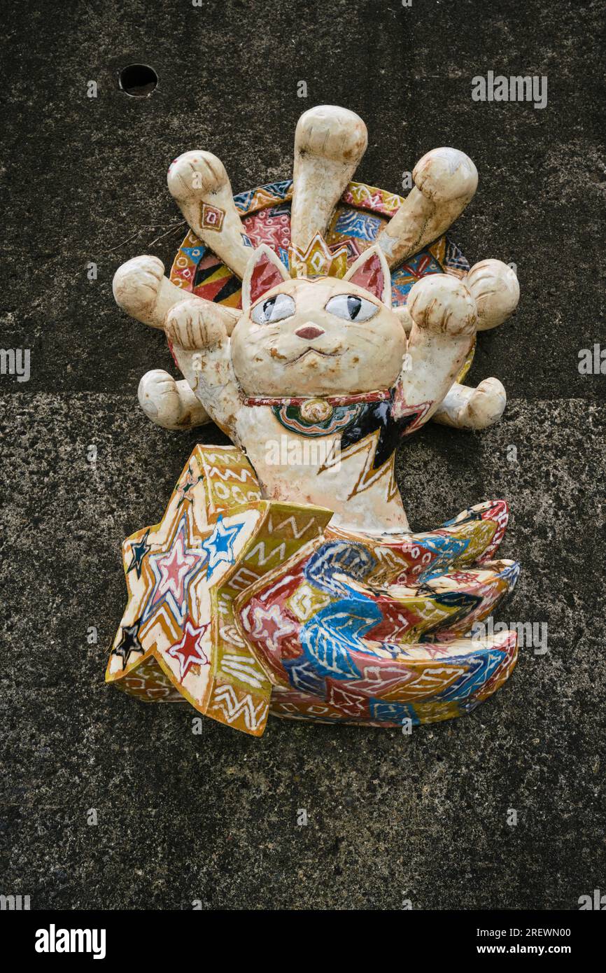 June 2023, Tokoname city. A ceramic beckoning cat (manekineko) along ...