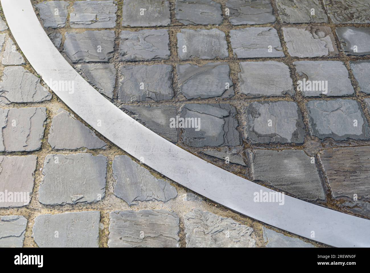 Metal arc insert in a stone pavement. Fragment circle. Different color ...