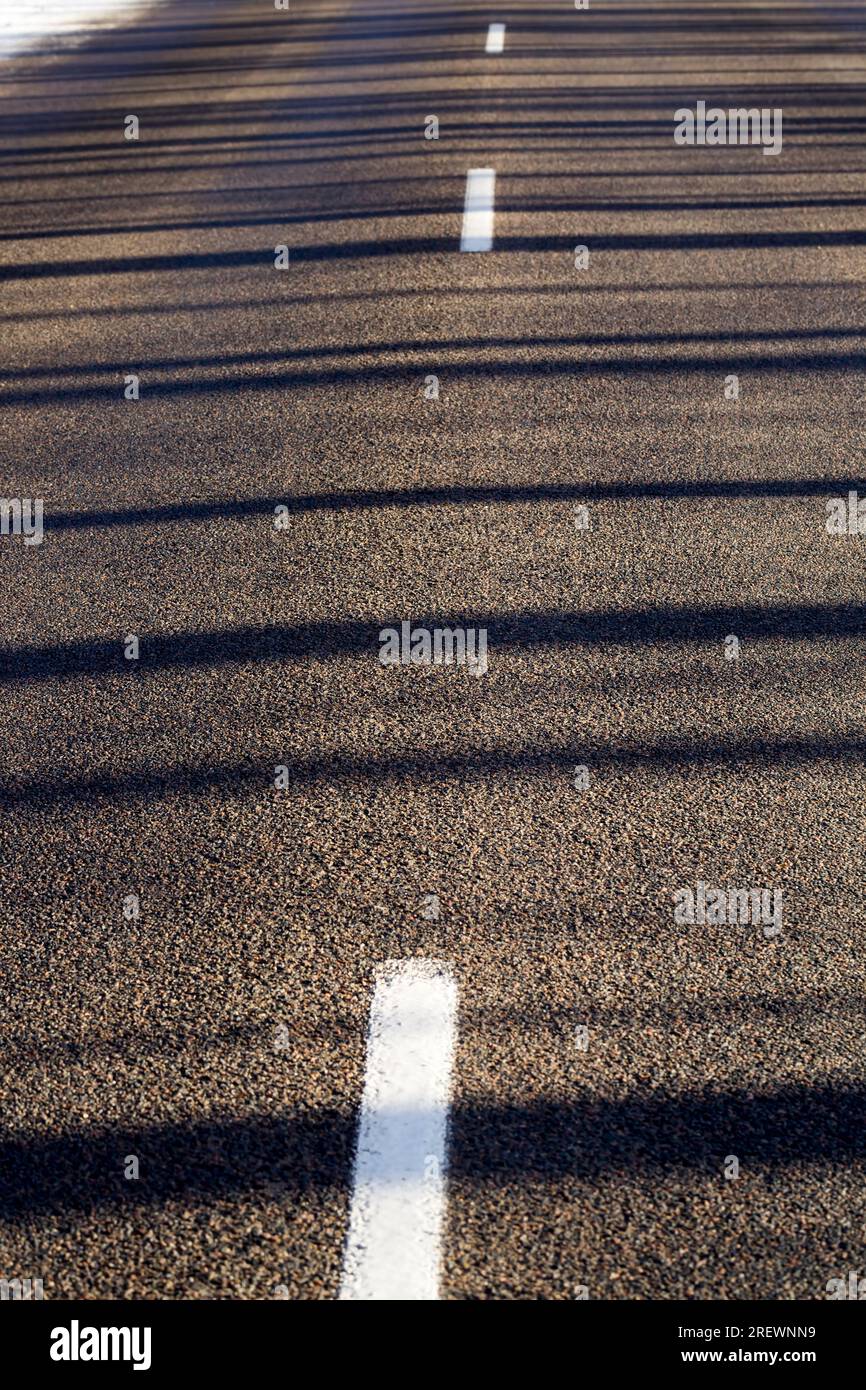 an old paved road with white road markings, the road is narrow and ...