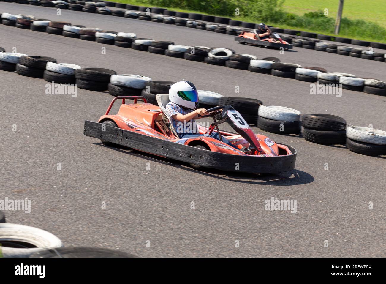 Youth Go Kart Racer on track. Dynamic image of teenage boy, moving fast ...