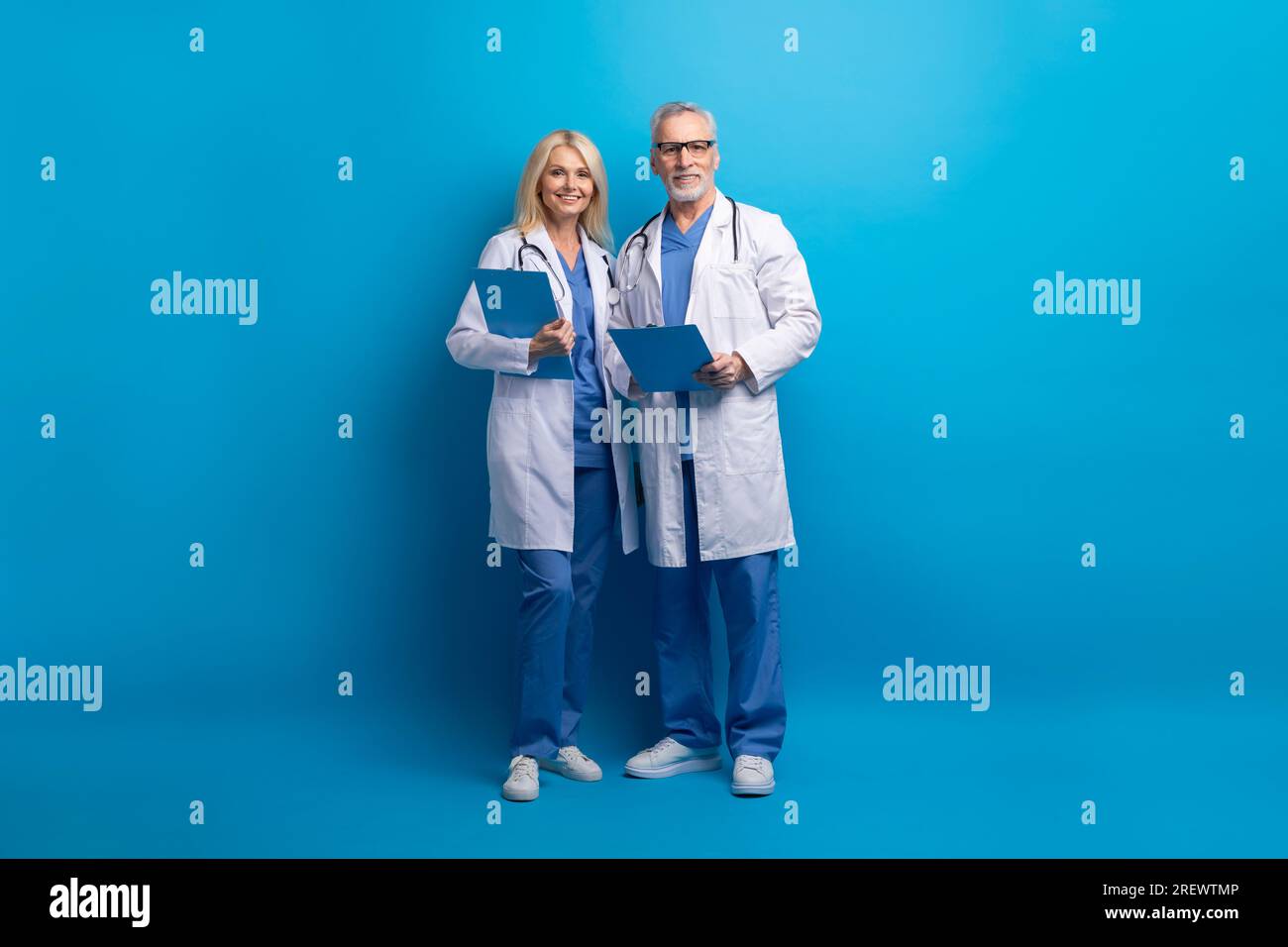 Senior doctors professional medical team posing on blue background ...