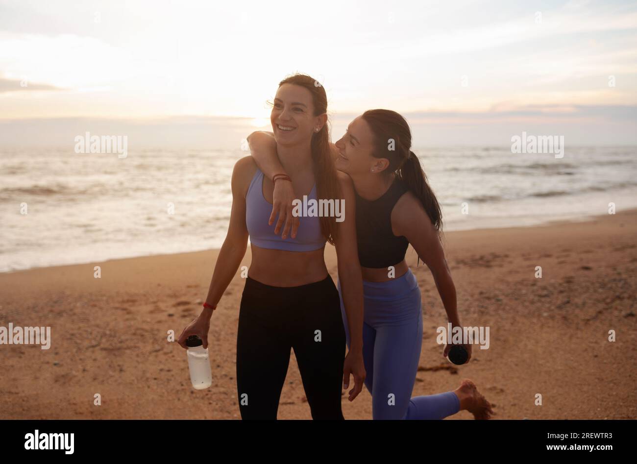 Smiling millennial caucasian twins sisters women hugging, have fun ...