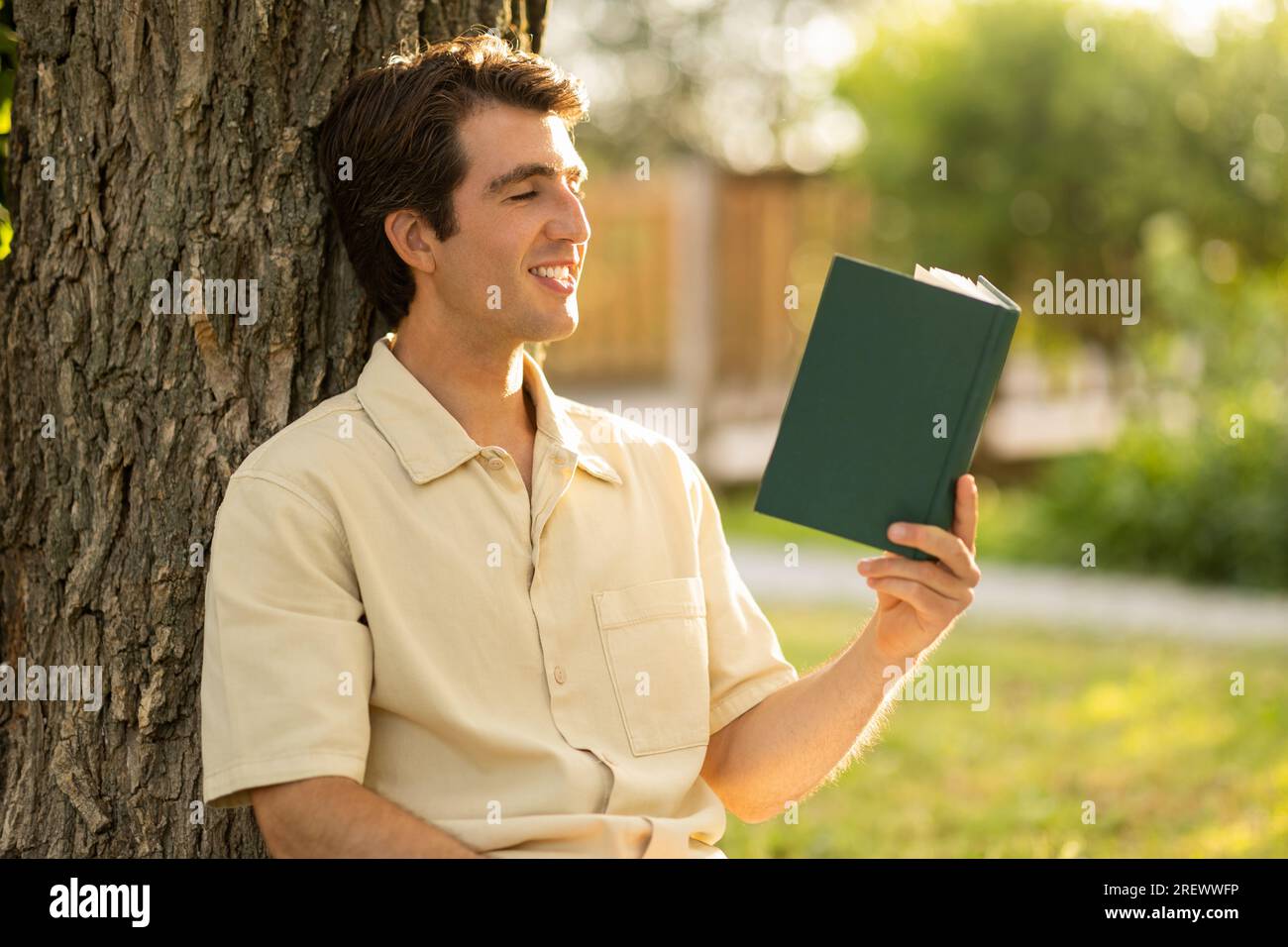 Man sitting under tree reading hi-res stock photography and images - Alamy