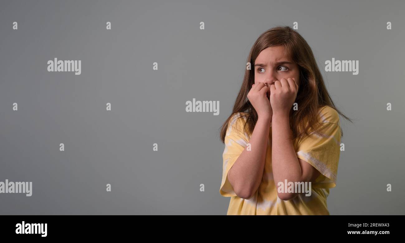 Scared child. banner on a gray background. Teen girl in a frightened ...