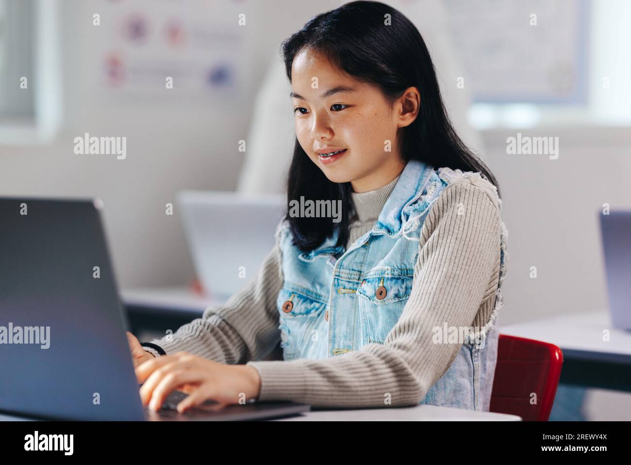 Asian kid nurturing her newly discovered tech talent as she learns to ...
