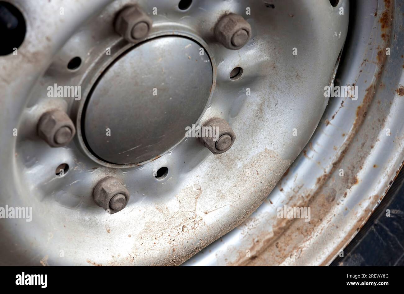 an old, rusting metal disc from a car wheel, on which a latex tire is ...