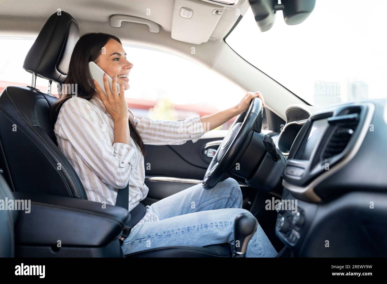 Happy millennial woman driver talking on phone while driving auto Stock ...