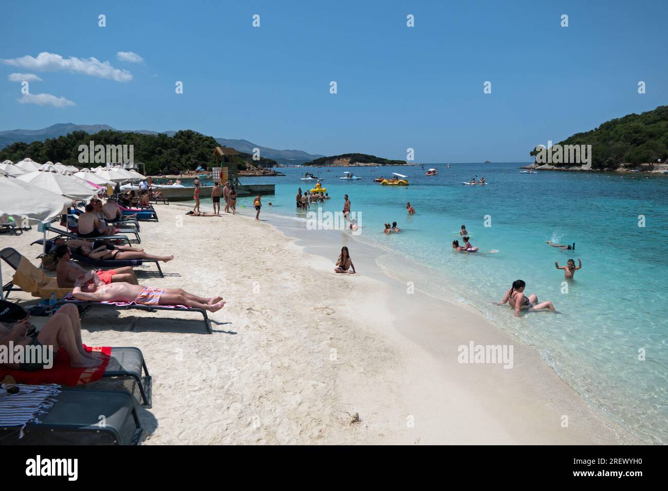 View of crowded beach in Ksamil, Albania with people swimming and ...
