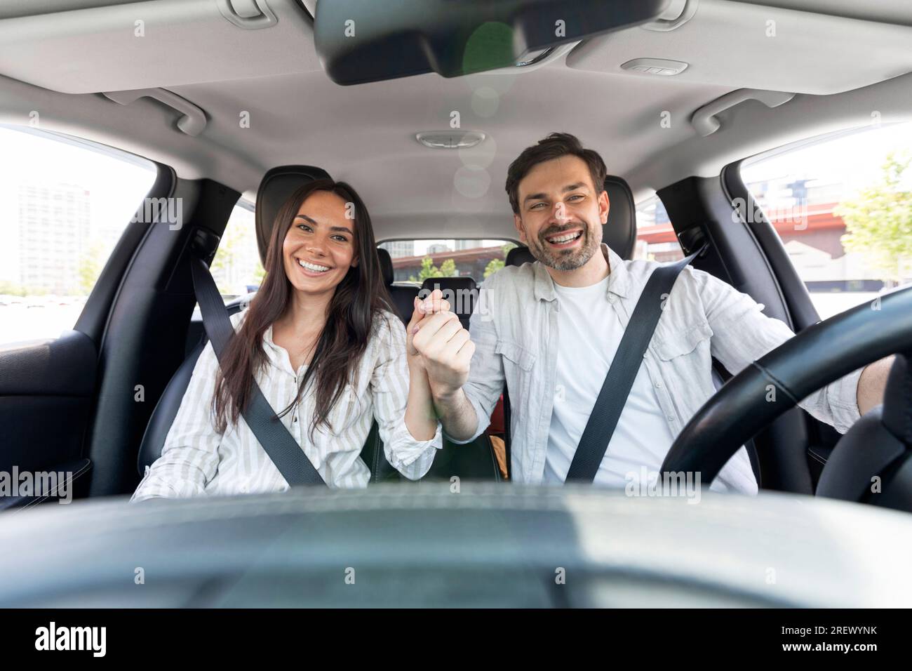 Excited loving couple sitting in car, holding hands and smiling Stock ...