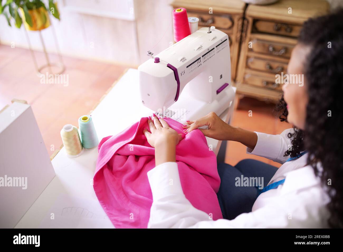 Seamstress Lady Sewing At Machine Sitting In Modern Dressmaking Atelier ...