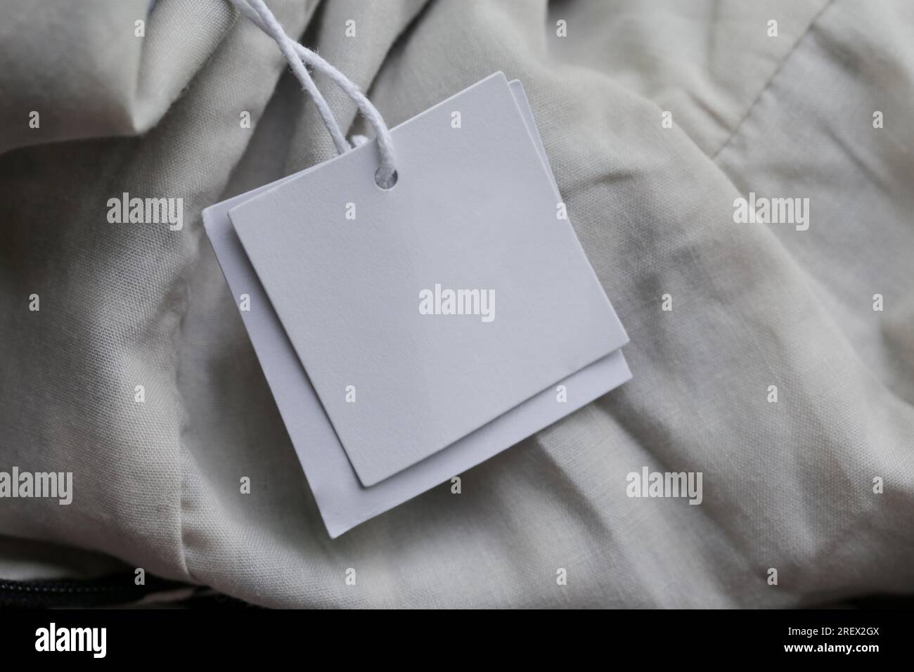 Close up of price tag of clothing item. Blank label tag mockup on ...