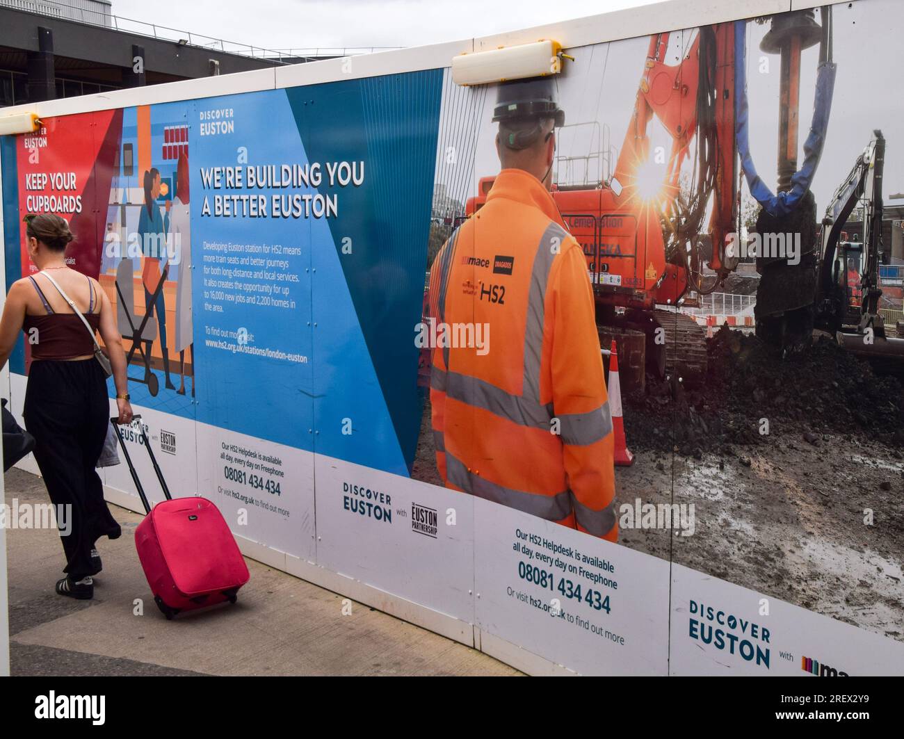 London, UK. 30th July 2023. A traveller walks past the HS2 construction ...