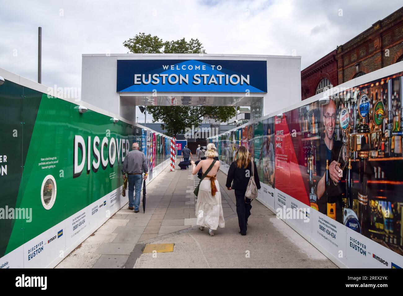 London, UK. 30th July 2023. Commuters walk past the HS2 construction ...