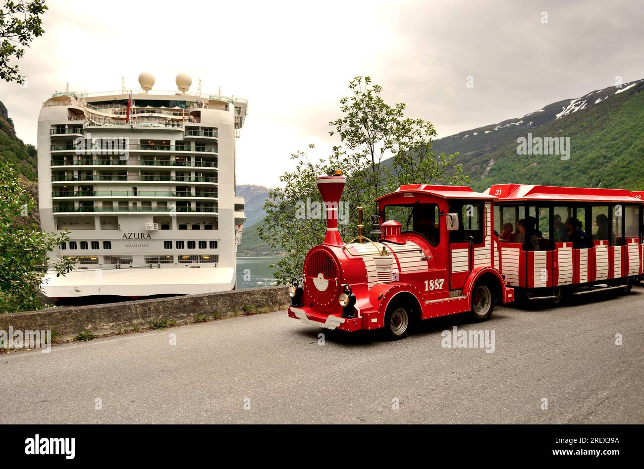 Land train carrying tourists past P&O cruise ship Azura moored at Flam ...