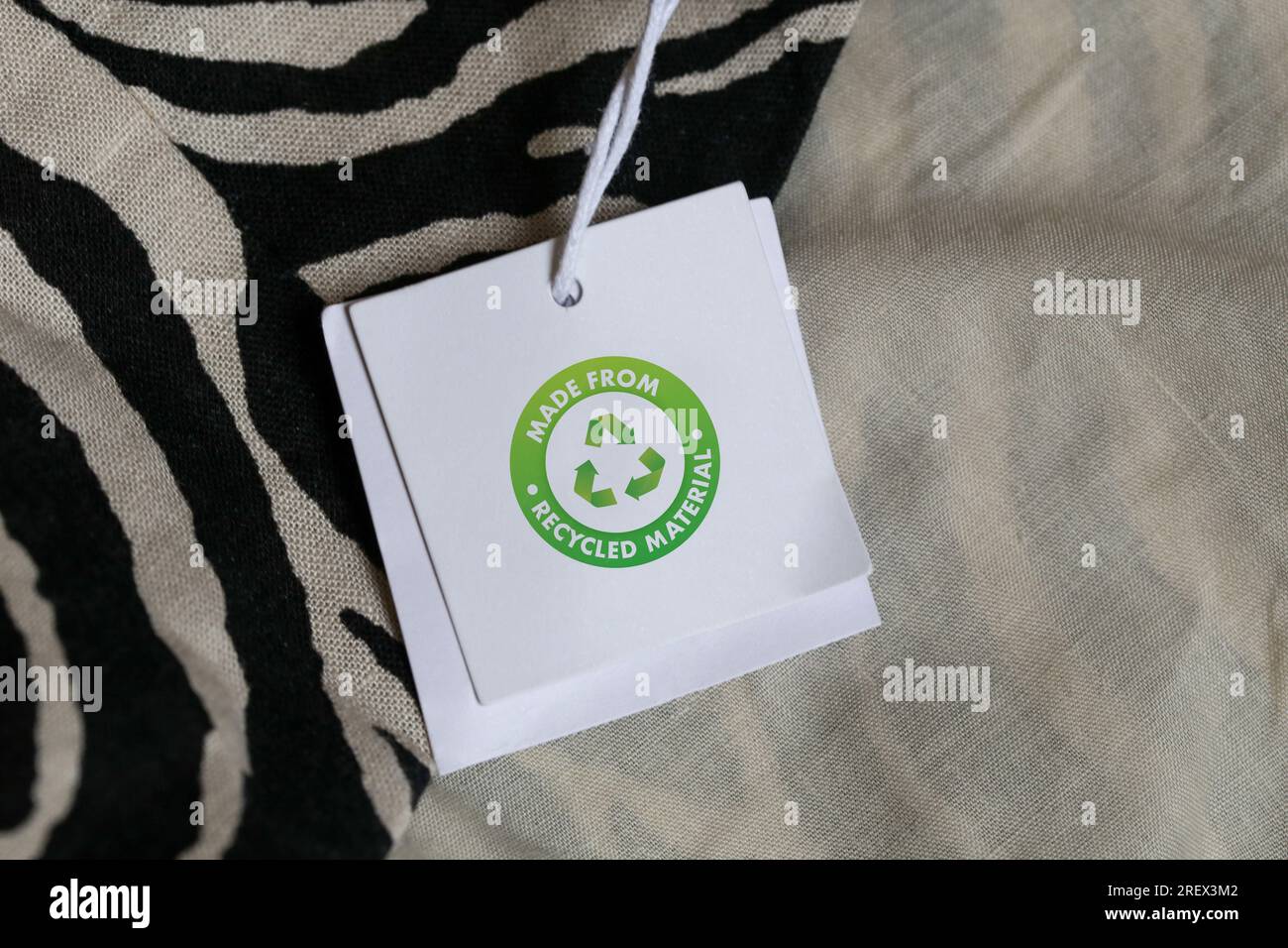 Close up of clothing tag with recycle icon. Recycling products concept ...