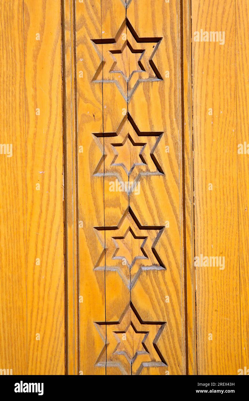part of a wooden door with carved religious stars of David, painted in ...