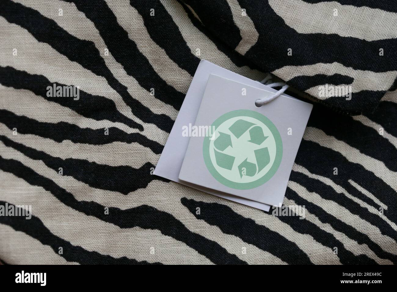 Close up of clothing tag with recycle icon. Recycling products concept ...