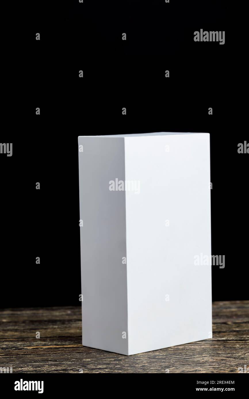 white paper or cardboard box on an old wooden table on a black ...