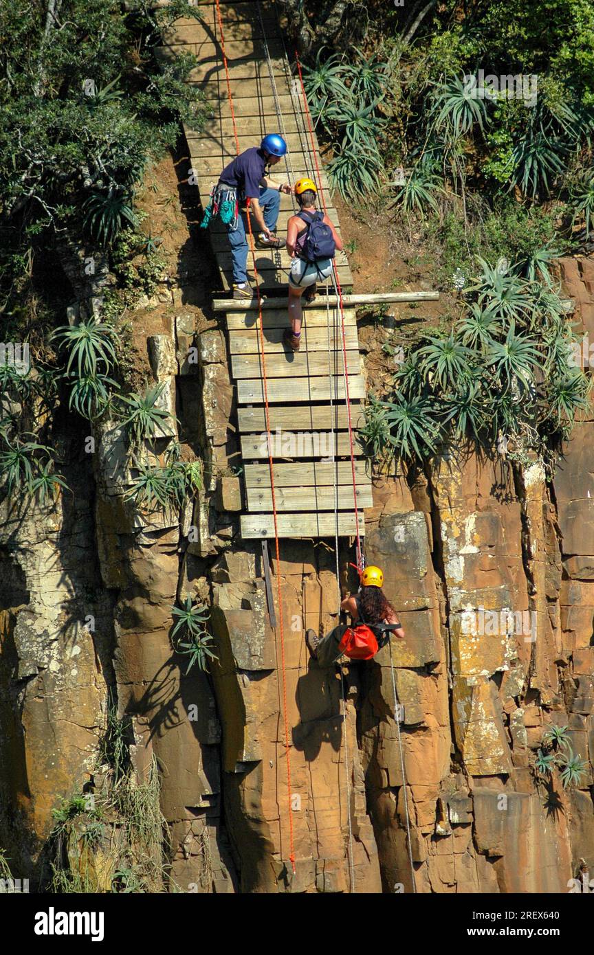 Group of people absolving from the edge of a platform down a cliff face ...