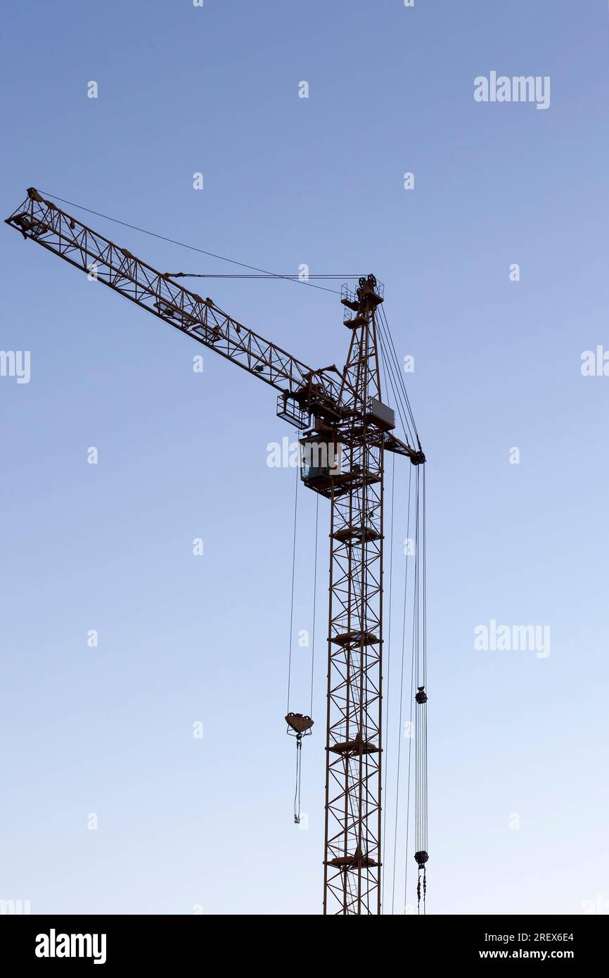 tall yellow construction crane on a building site for the construction ...
