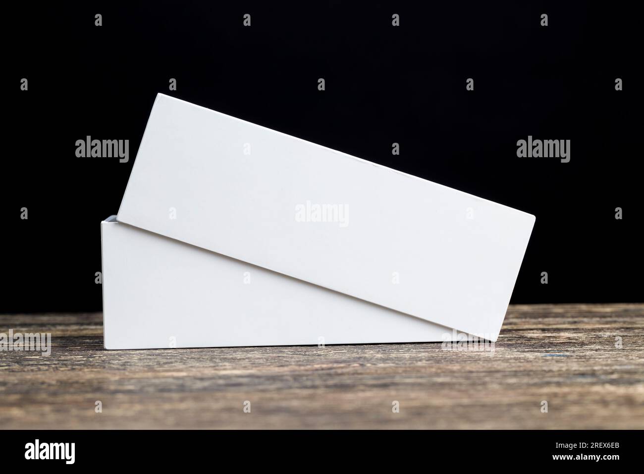 white paper or cardboard box on an old wooden table on a black ...
