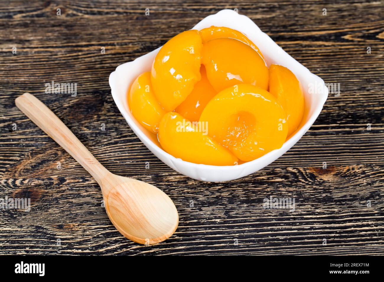 closeup canned ripe orange peaches, fruit preserved in sweet syrup with ...