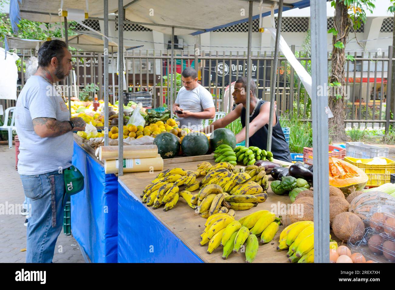 Niteroi, Brazil, A man buys fresh produce from a kiosk where another ...