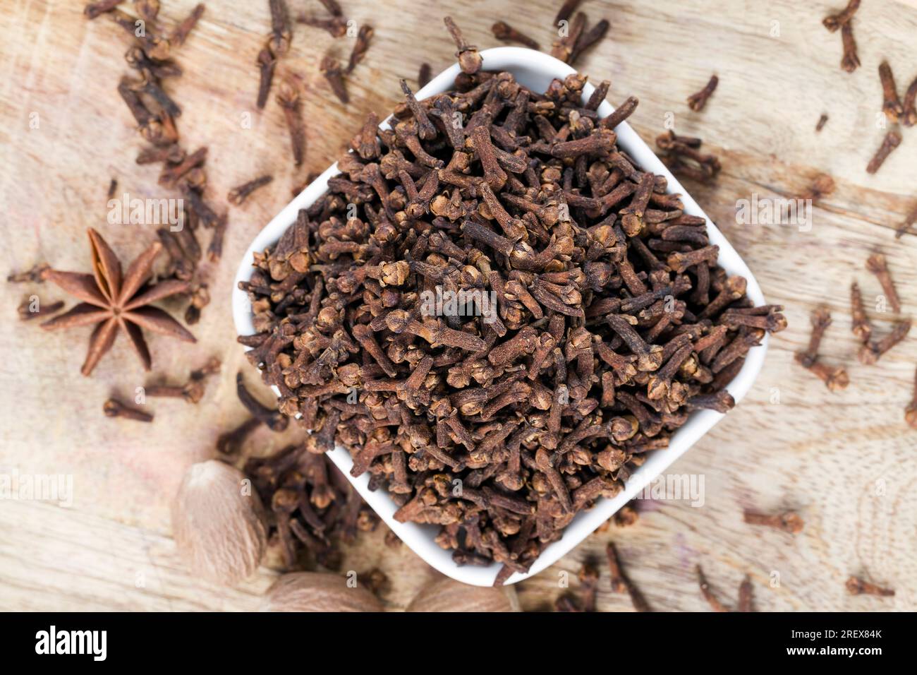 spices of cloves scattered on an old wooden table in the kitchen ...
