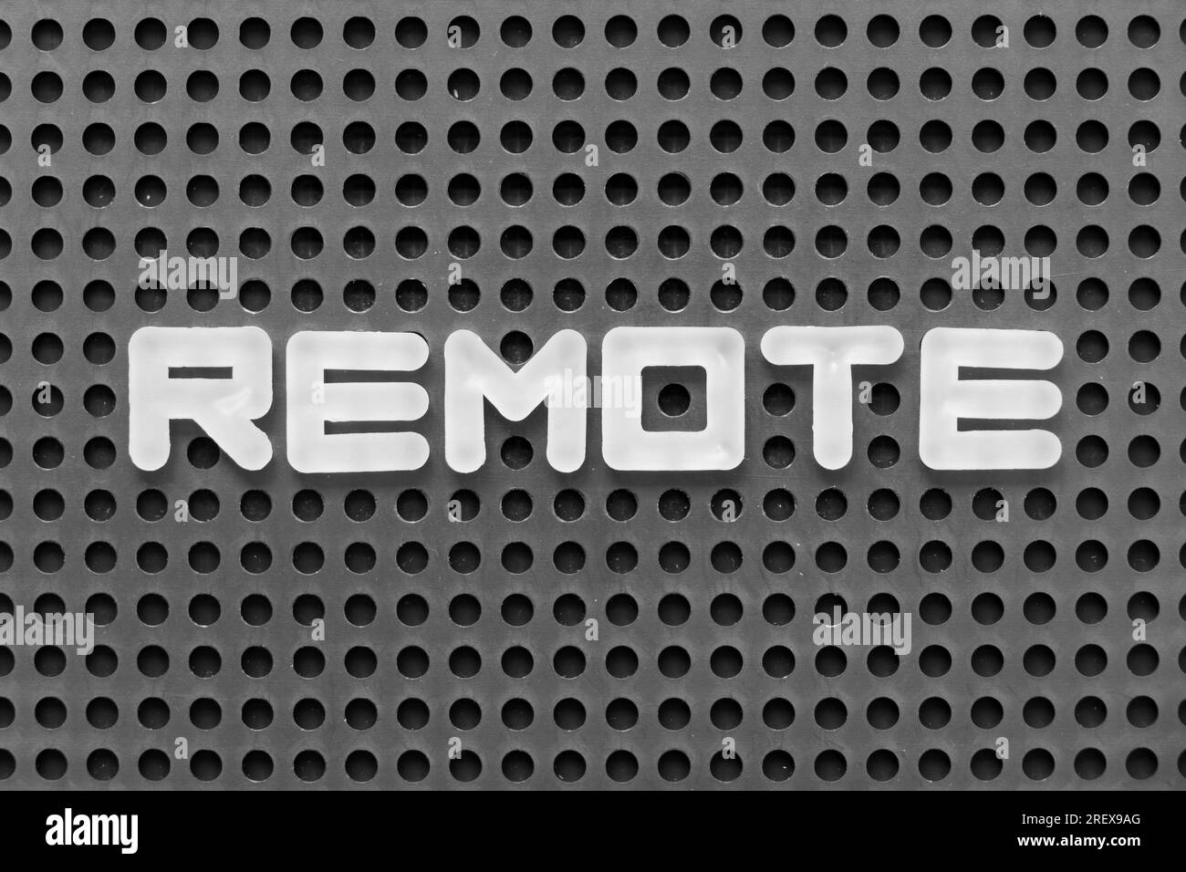 White alphabet letter in word remote on black pegboard background Stock ...