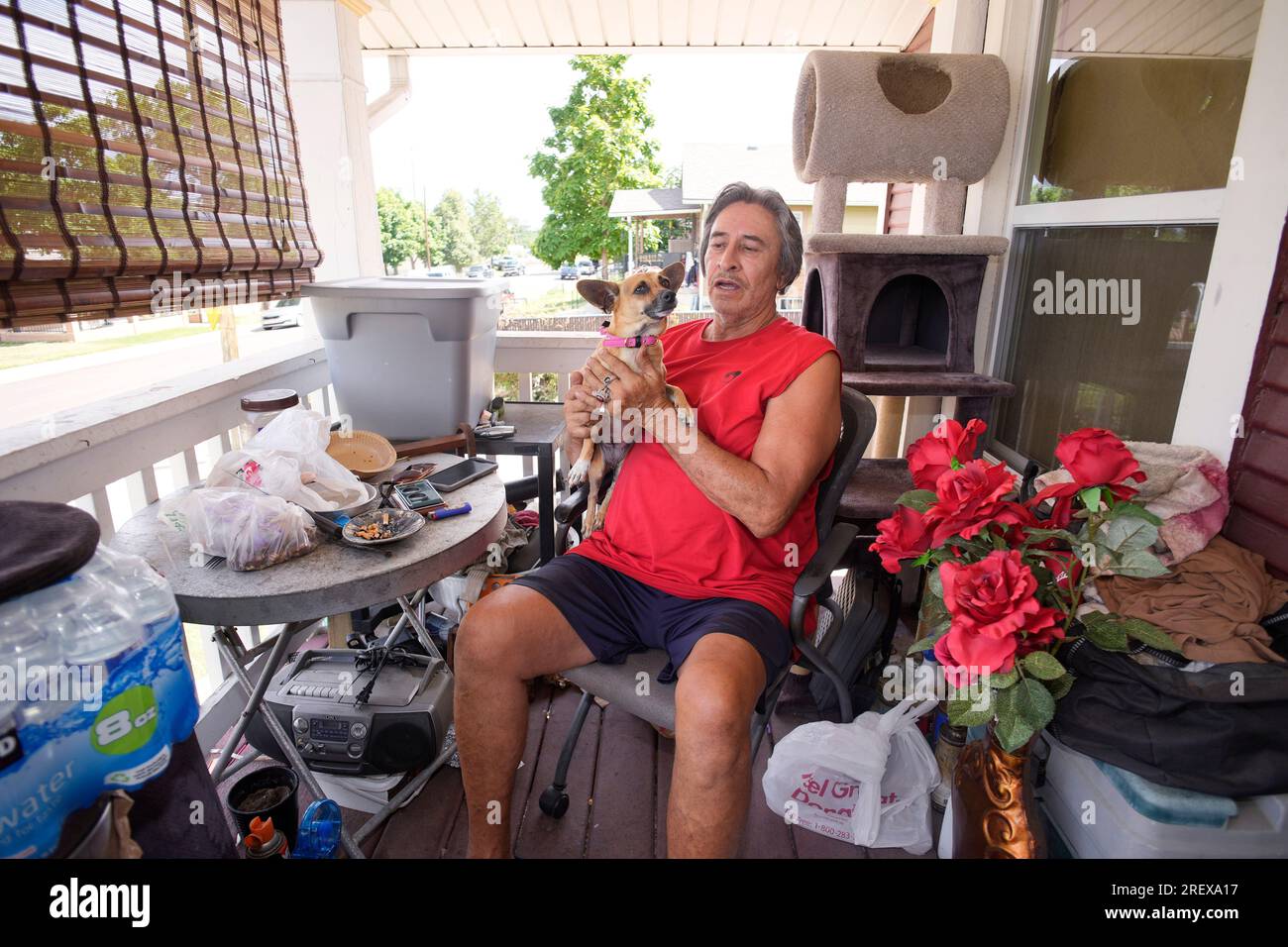 Ben Gallegos sits on the porch of his family's home in the Globeville neighborhood with his dog ...