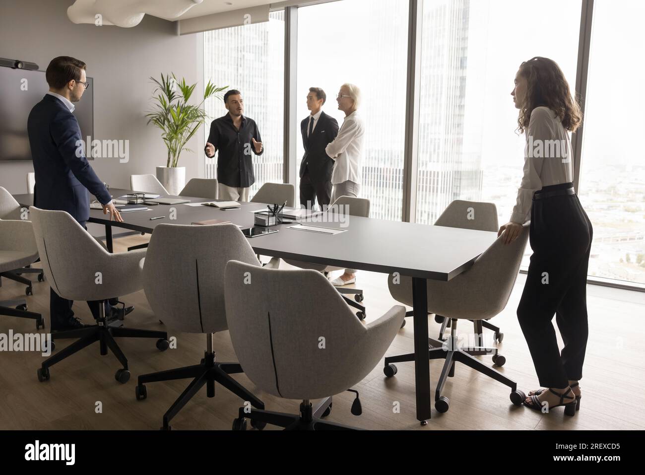 Business team standing at large office conference table talking Stock ...